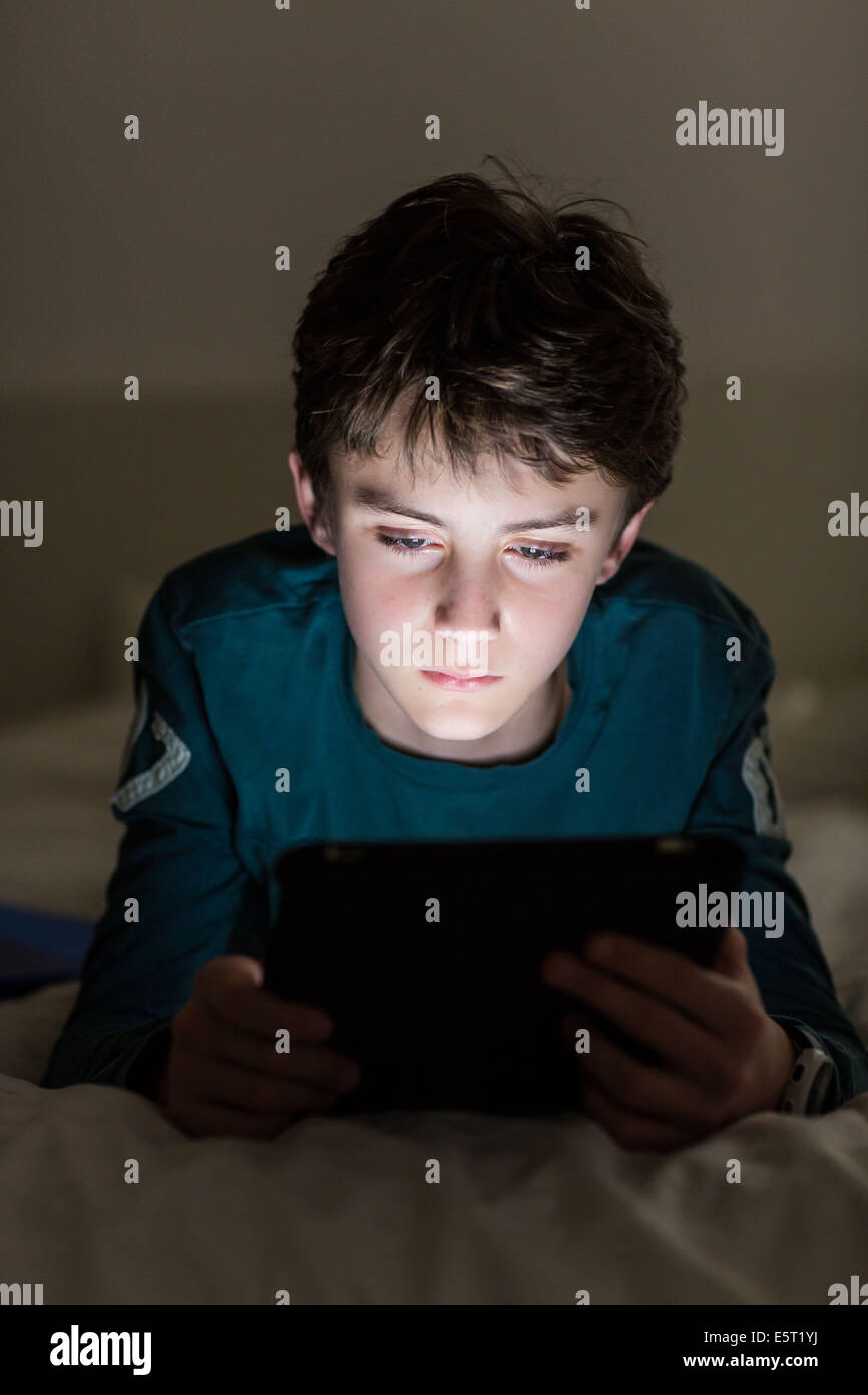 Teenage boy using a digital tablet at night Stock Photo - Alamy