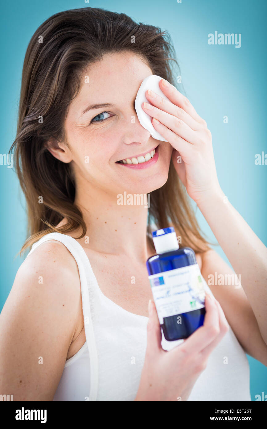 Woman applying a compress on the eyes with floral water Stock Photo - Alamy