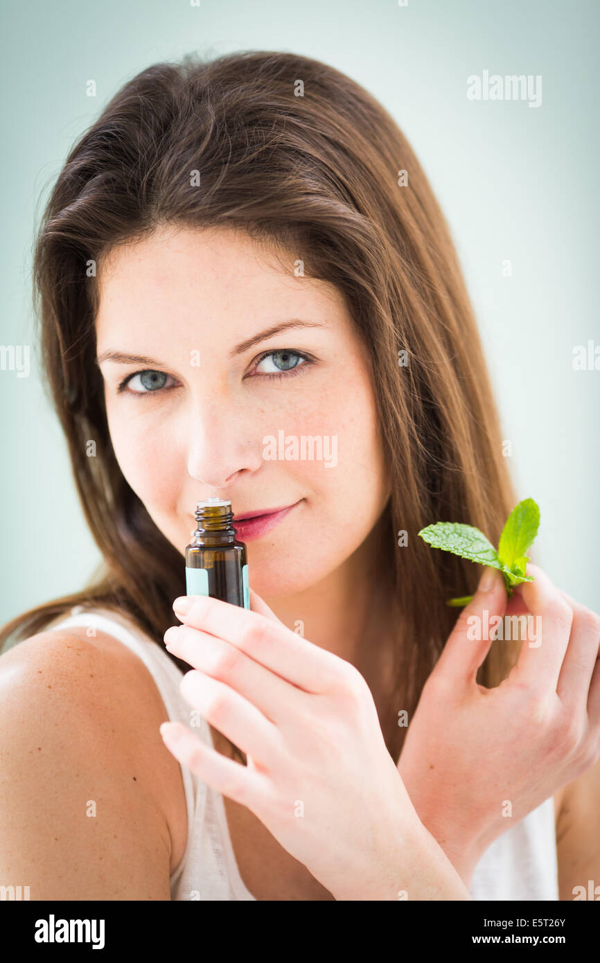 Woman smelling a bottle of mint essential oil Stock Photo - Alamy