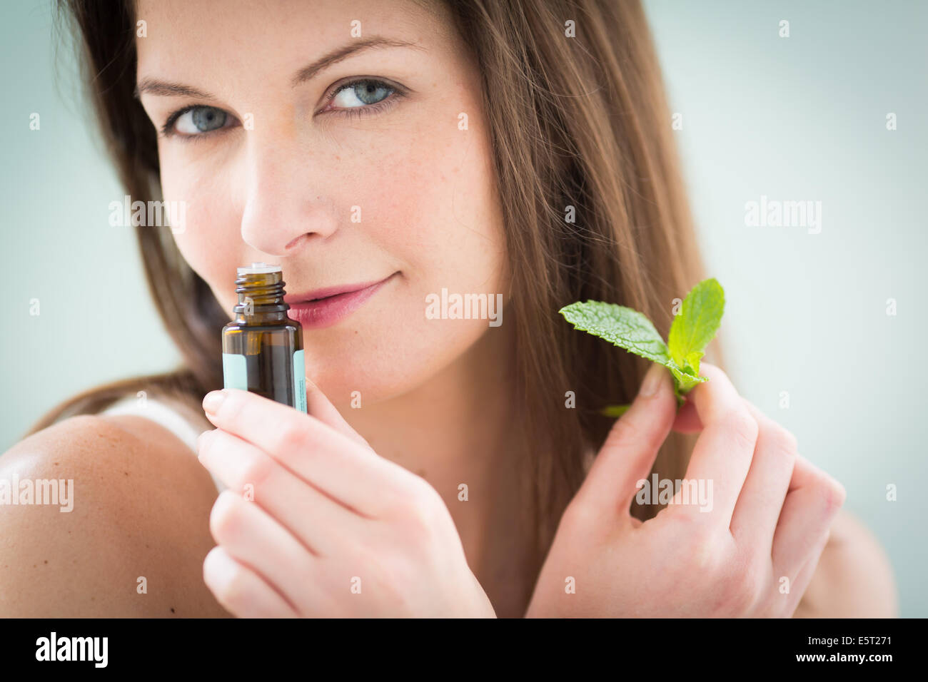 Woman smelling a bottle of mint essential oil Stock Photo - Alamy