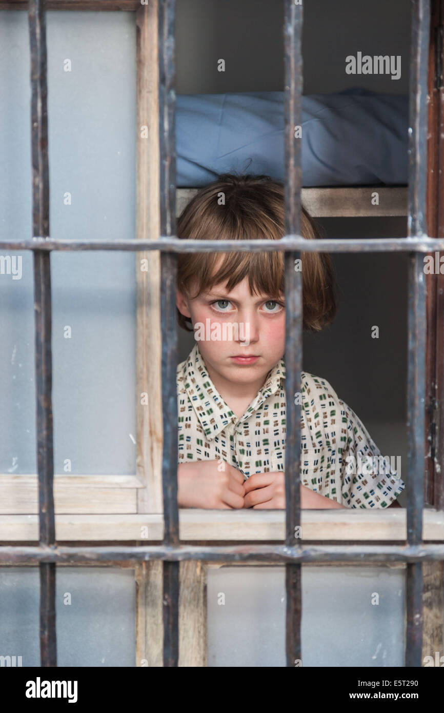 Boy behind a window fence Stock Photo - Alamy