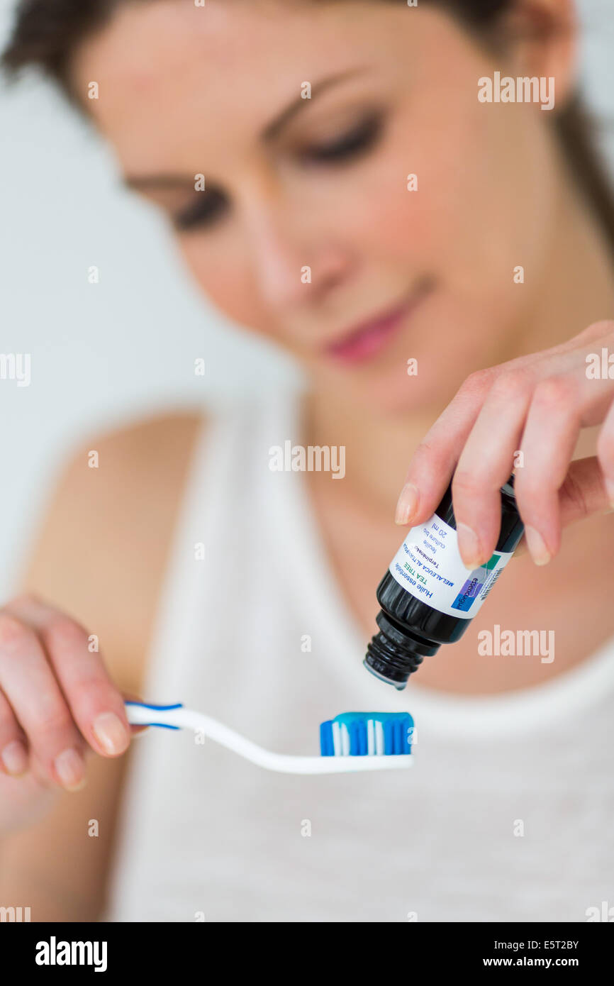 Woman pouring tea tree essential oil on her toothpaste Stock Photo - Alamy