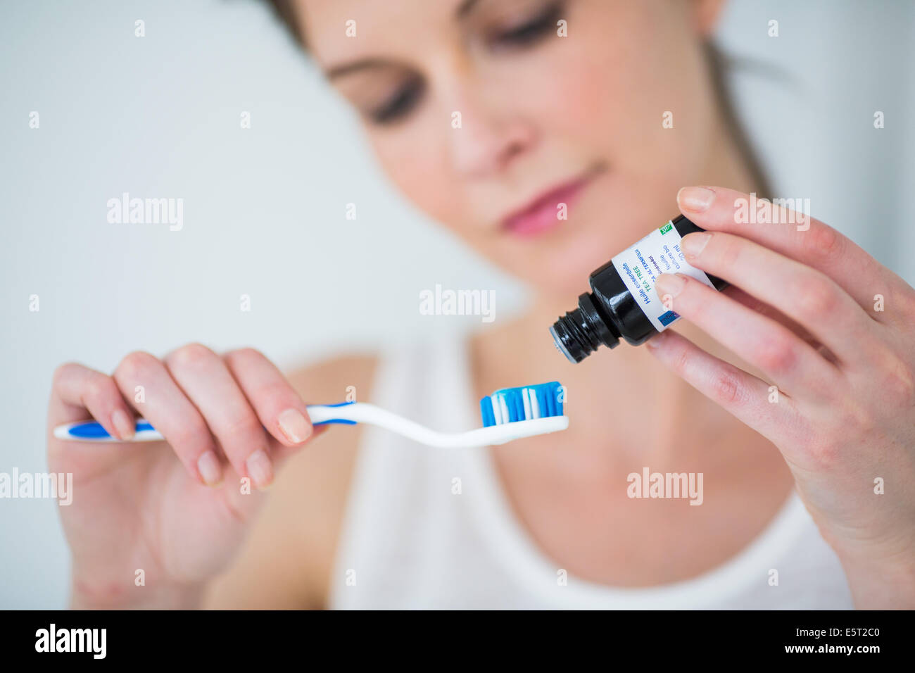 Woman pouring tea tree essential oil on her toothpaste Stock Photo - Alamy