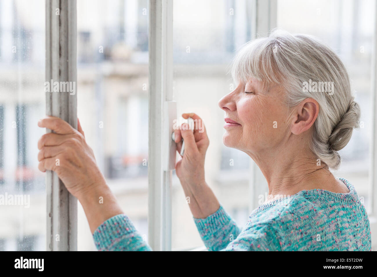 Woman opening window Stock Photo - Alamy