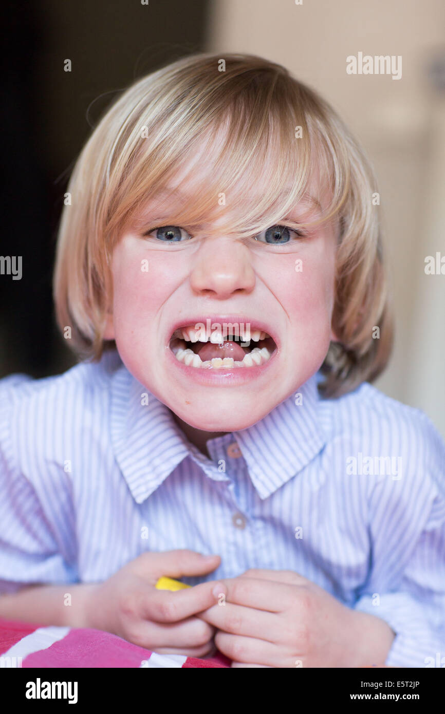 7 year old boy shows a missing tooth and a loose tooth Stock Photo - Alamy