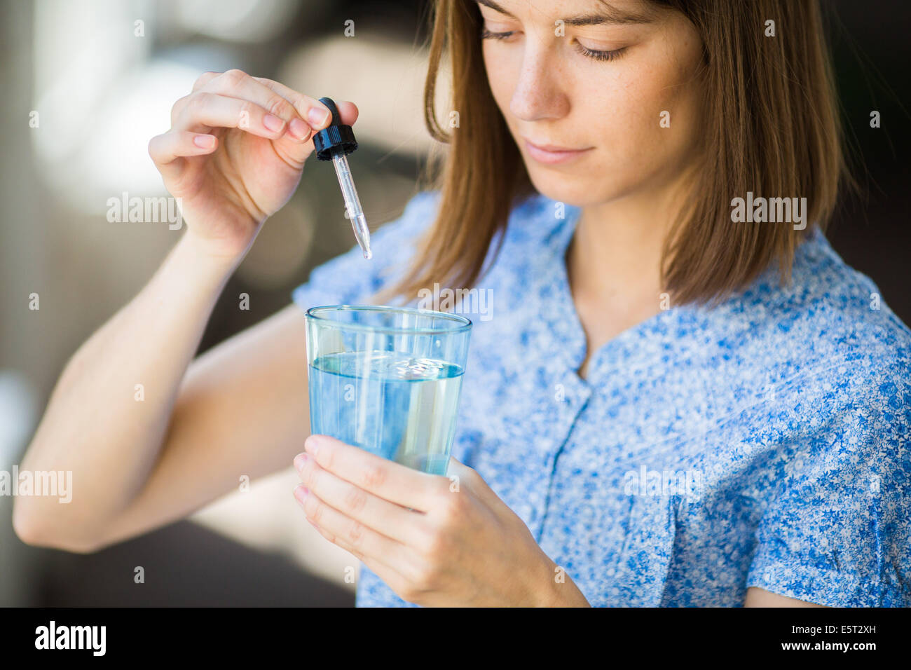 Woman taking drops of medicine Stock Photo - Alamy