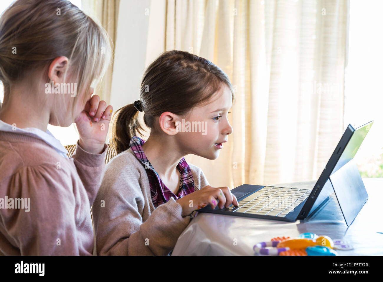 Sisters using laptop computer Stock Photo - Alamy