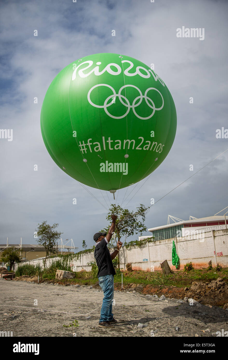 A worker carries a huge balloon next to the Olympic Park in Barra two ...