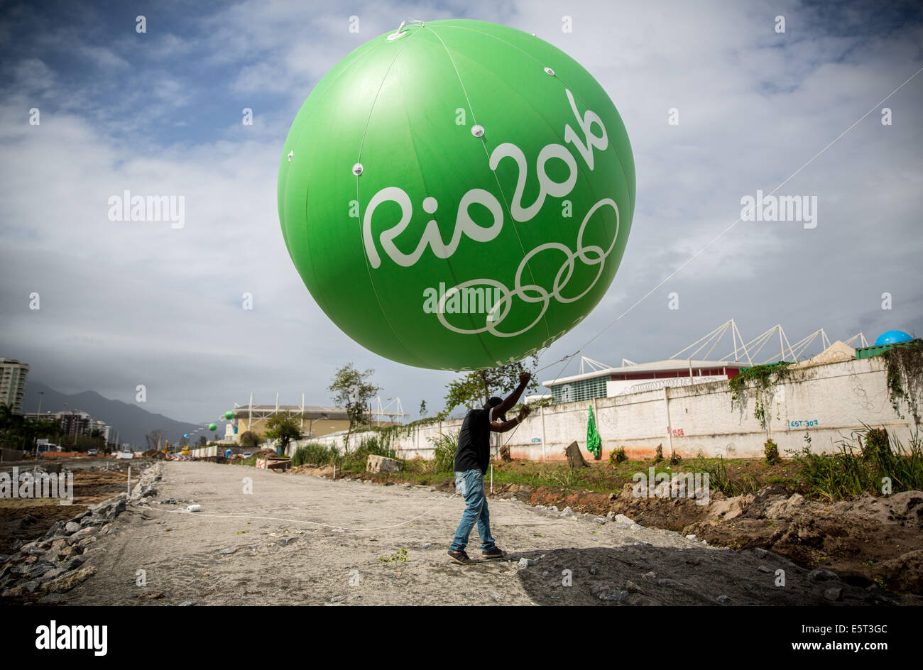 A worker carries a huge balloon next to the Olympic Park in Barra two ...