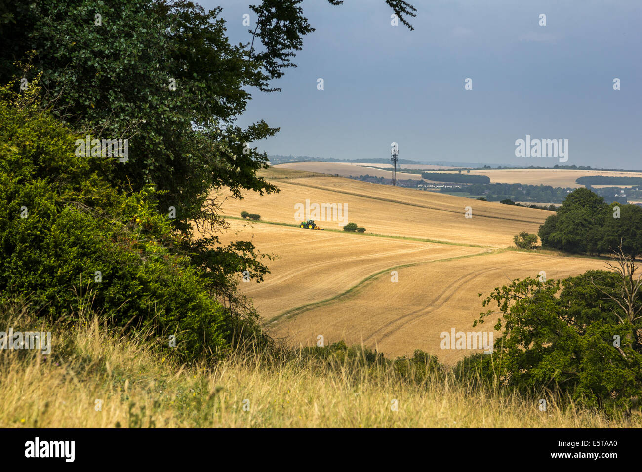 A tractor in a hillside scene with houses in the background Stock Photo ...