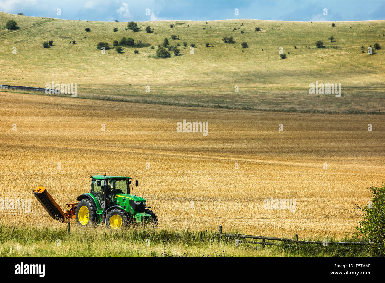 A tractor in a field harvesting his crops Stock Photo - Alamy