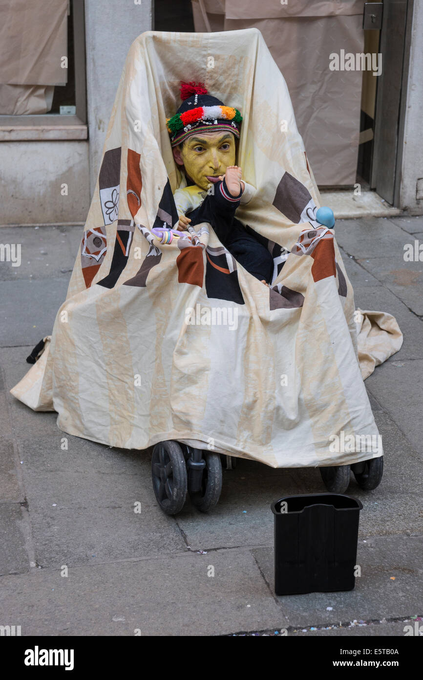 Street performer playing a baby on a main pedestrian thoroughfare ...
