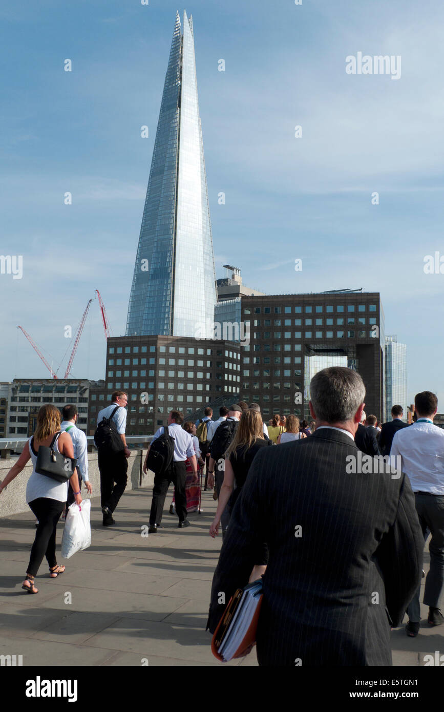 City of London office workers walking across London Bridge after work ...