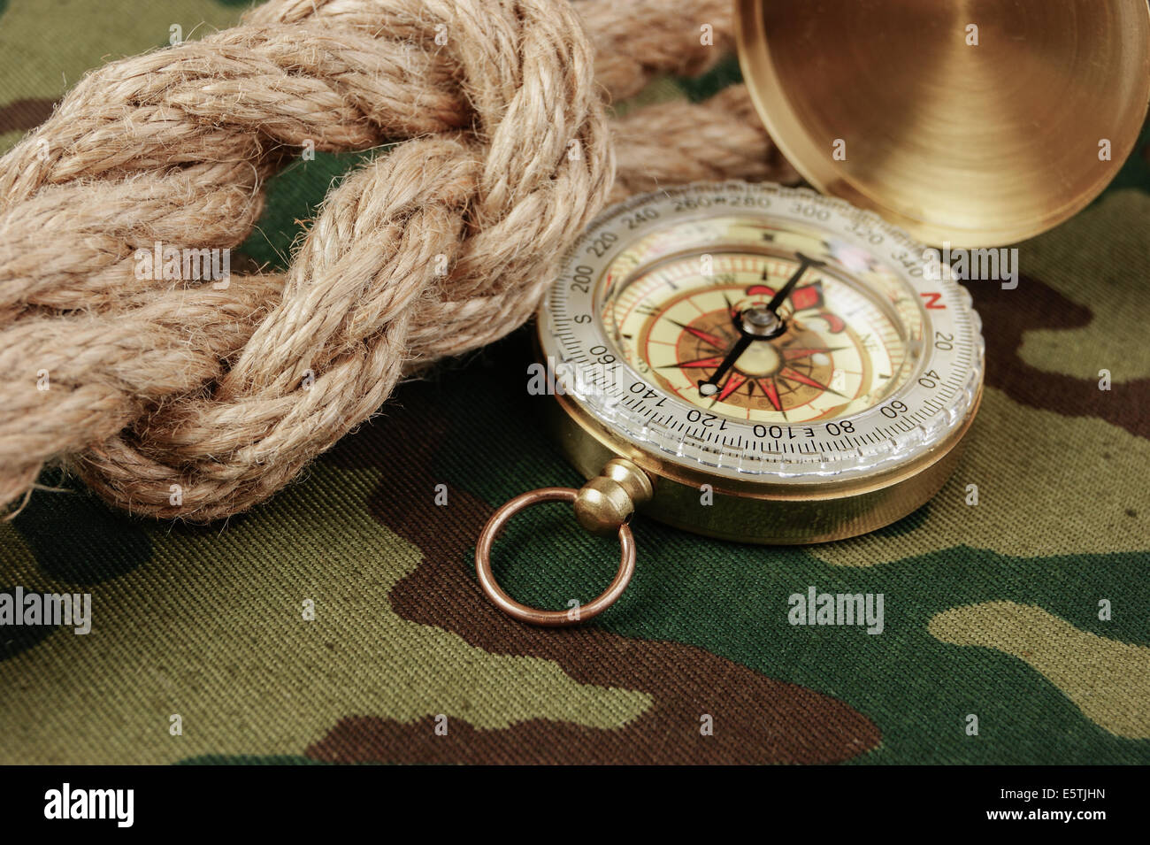 Compass and rope on a camouflage background Stock Photo - Alamy