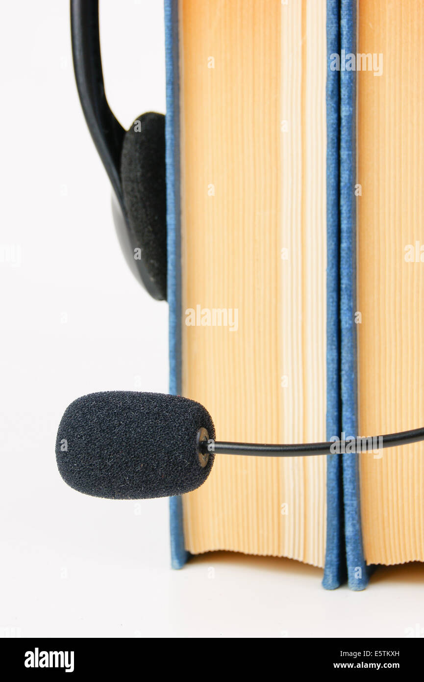 Headphones with a microphone and a stack of books on white background ...