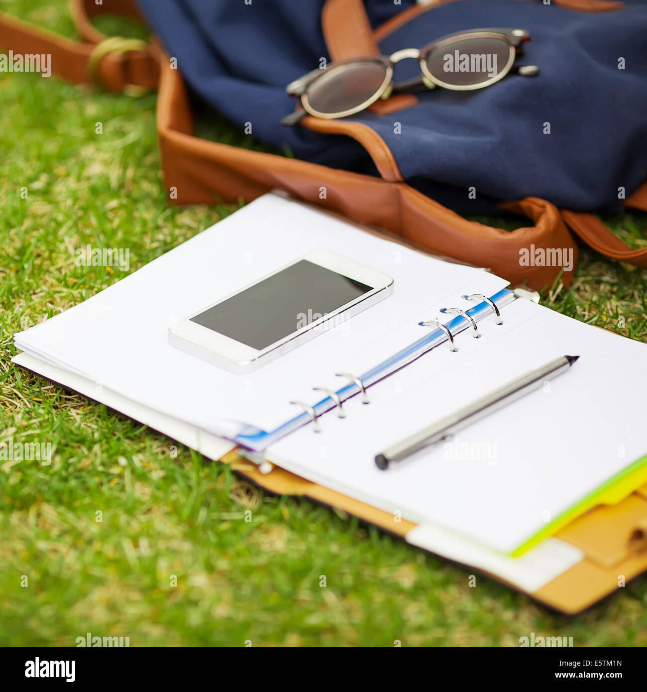Modern digital notebook with mobile smartphone on green grass Stock ...