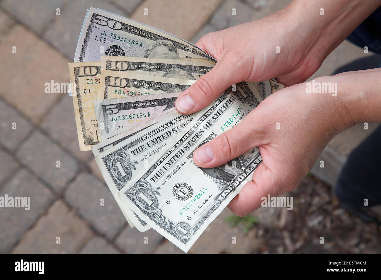 A person holding and counting American dollar notes Stock Photo - Alamy