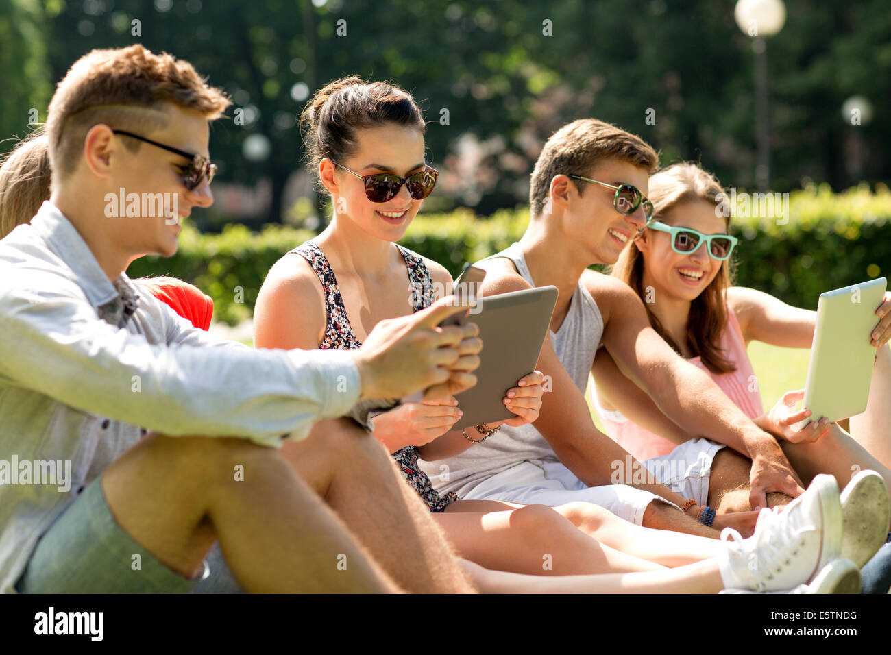 smiling friends with tablet pc computers in park Stock Photo - Alamy