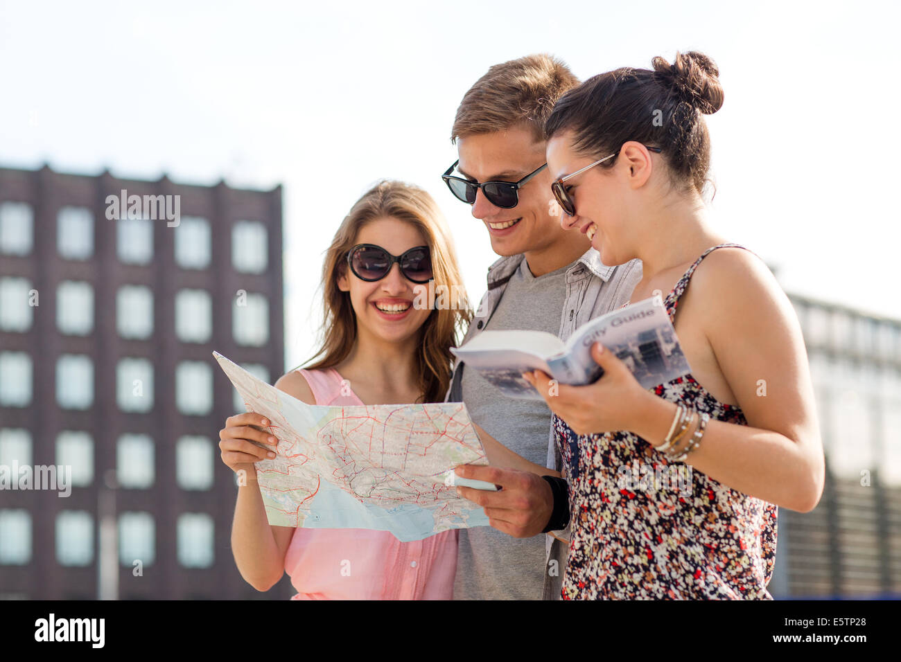 smiling friends with map and city guide outdoors Stock Photo - Alamy