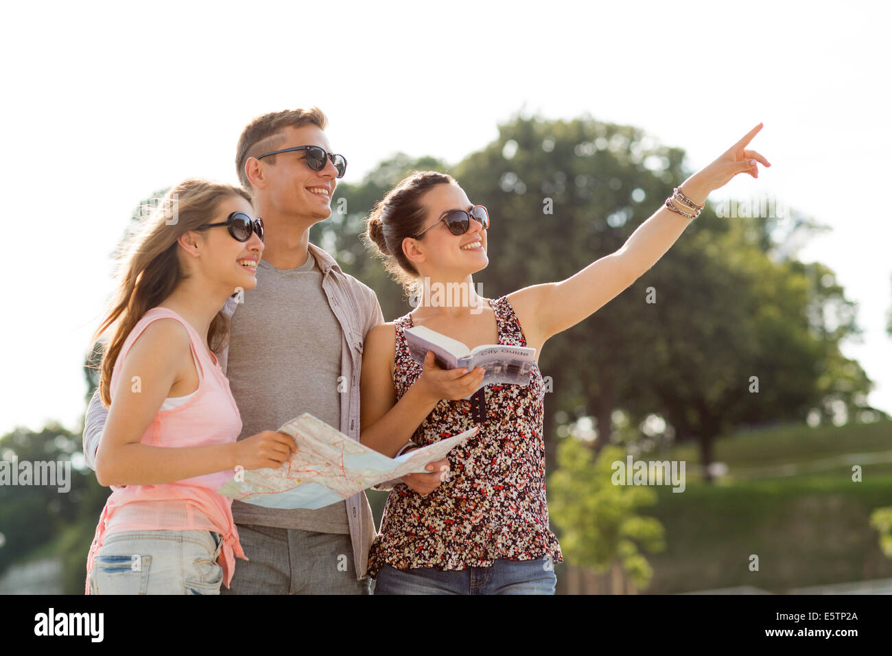 smiling friends with map and city guide outdoors Stock Photo - Alamy