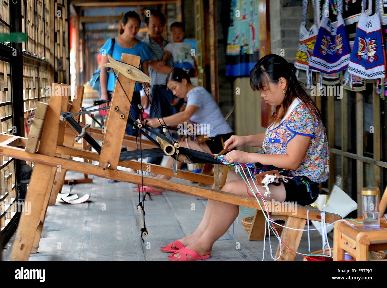 Enshi. 6th Aug, 2014. Girls of Tujia ethnic group make Tujia brocade ...