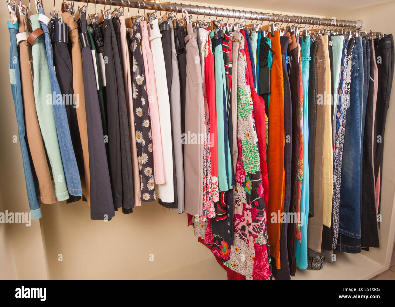 Variety of colorful womens clothing hanging on rail in fashion shop ...