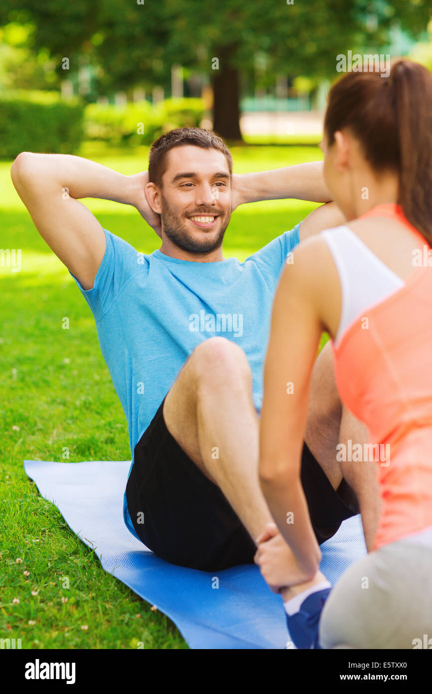 smiling man doing exercises on mat outdoors Stock Photo - Alamy
