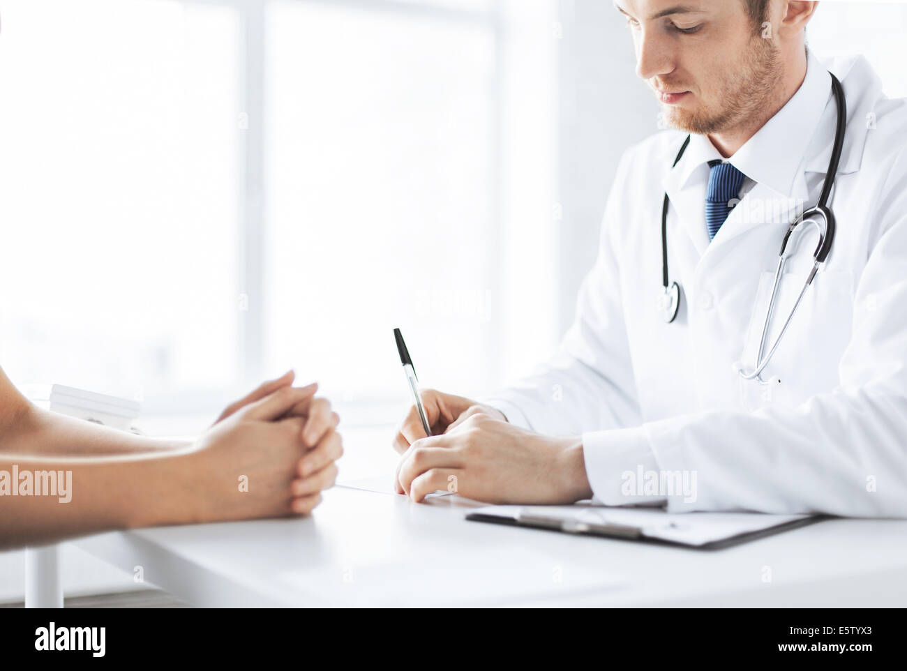 patient and doctor taking notes Stock Photo - Alamy