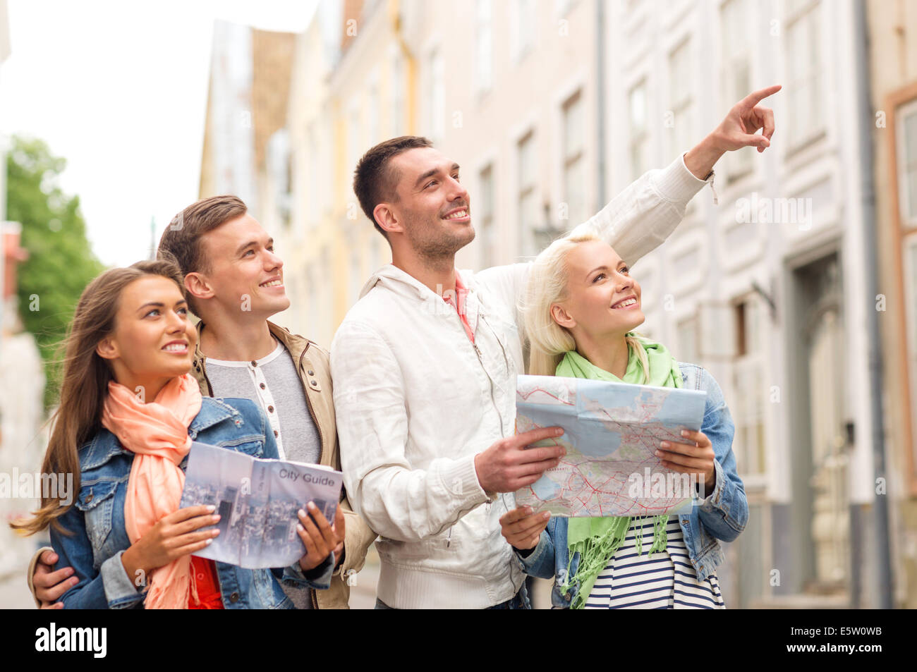 group of smiling friends with city guide and map Stock Photo - Alamy