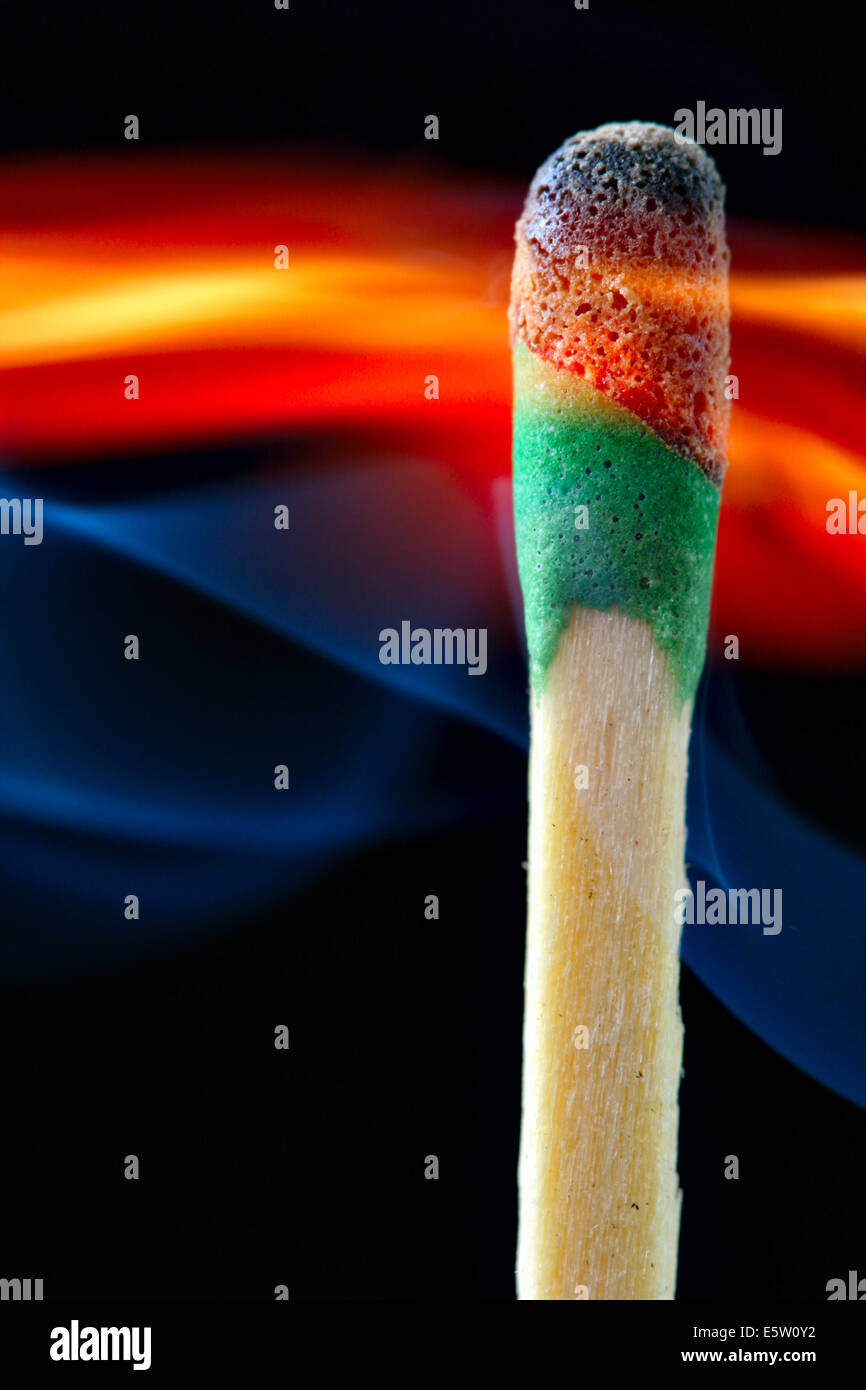 Burning match with blue smoke over black background Stock Photo - Alamy