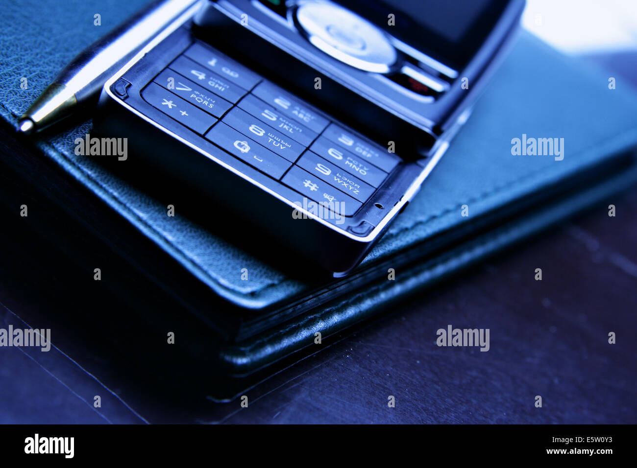 Cellular phone and pen on leather organizer Stock Photo - Alamy