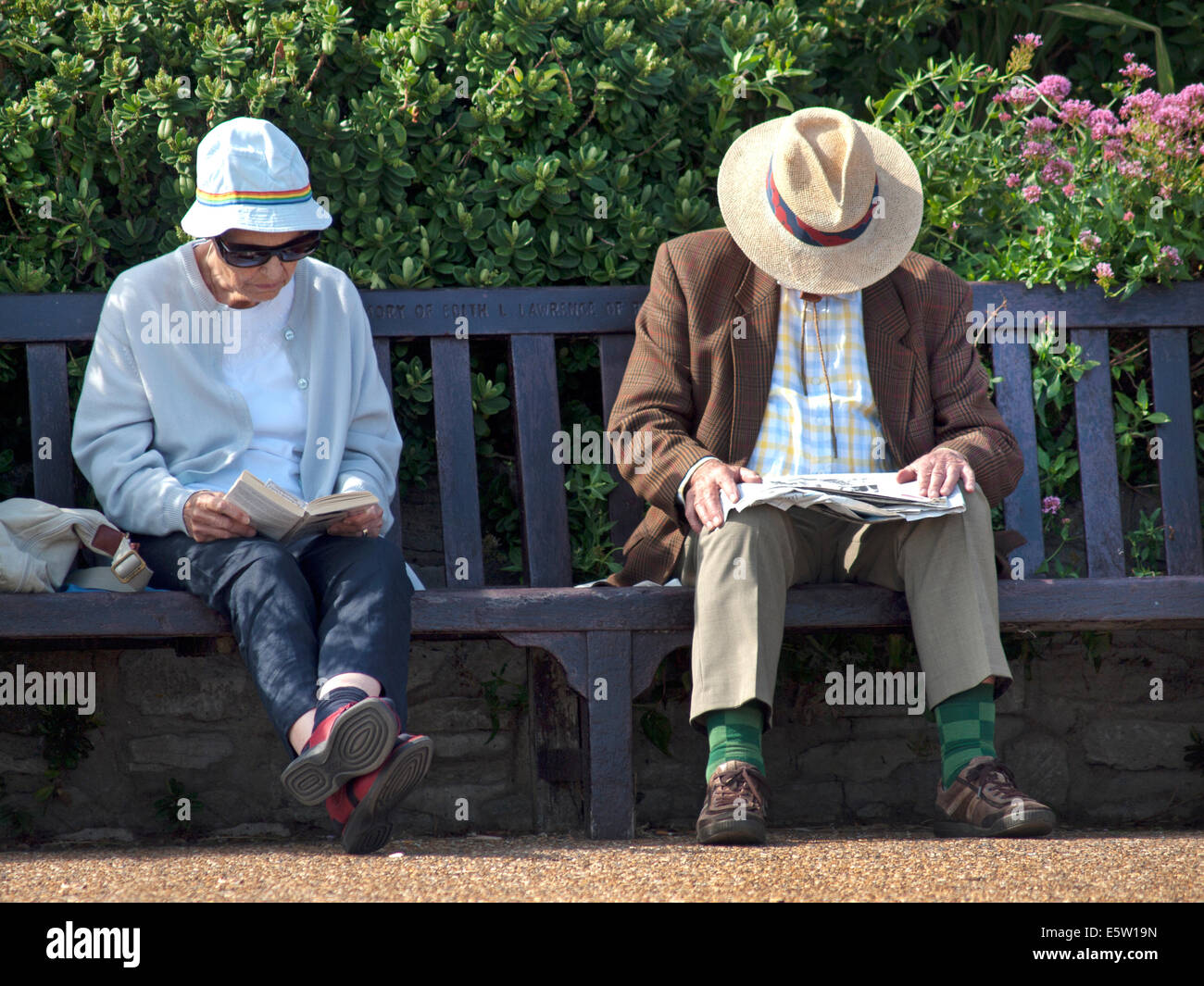 Sitting and reading on a park bench in Eastbourne Stock Photo - Alamy