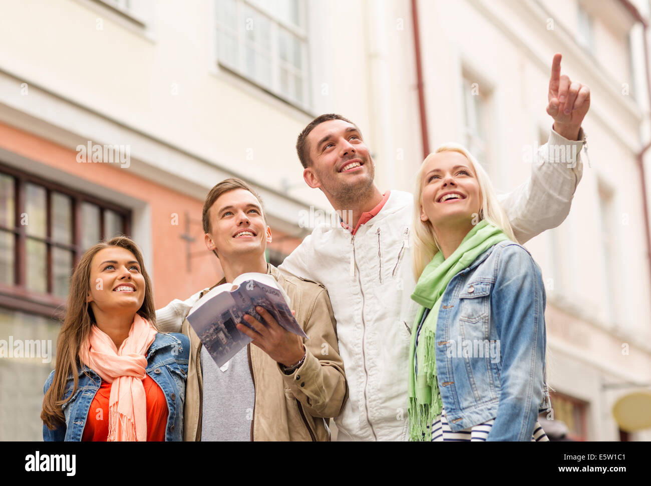 group of friends with city guide exploring town Stock Photo - Alamy