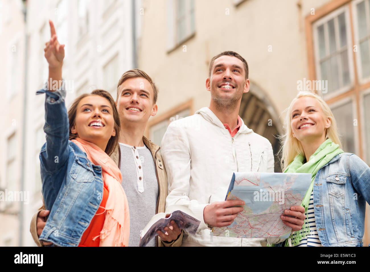 group of smiling friends with city guide and map Stock Photo - Alamy