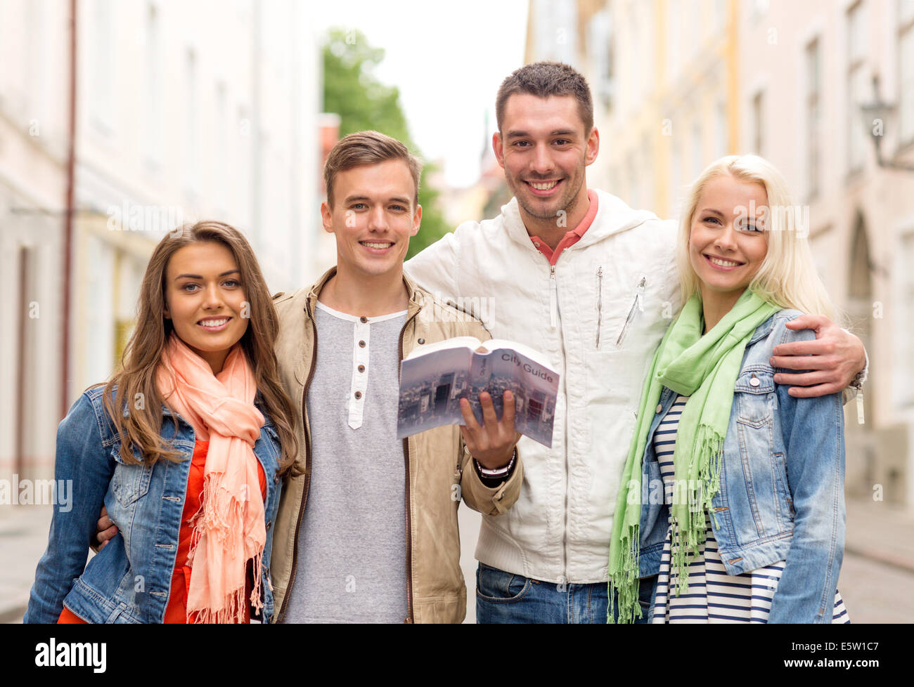 group of friends with city guide exploring town Stock Photo - Alamy