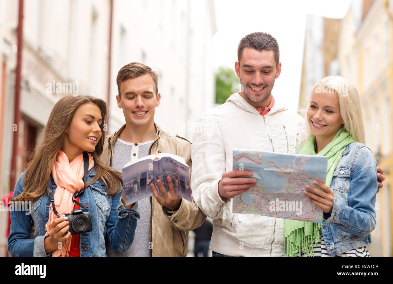 group of friends with city guide, map and camera Stock Photo - Alamy
