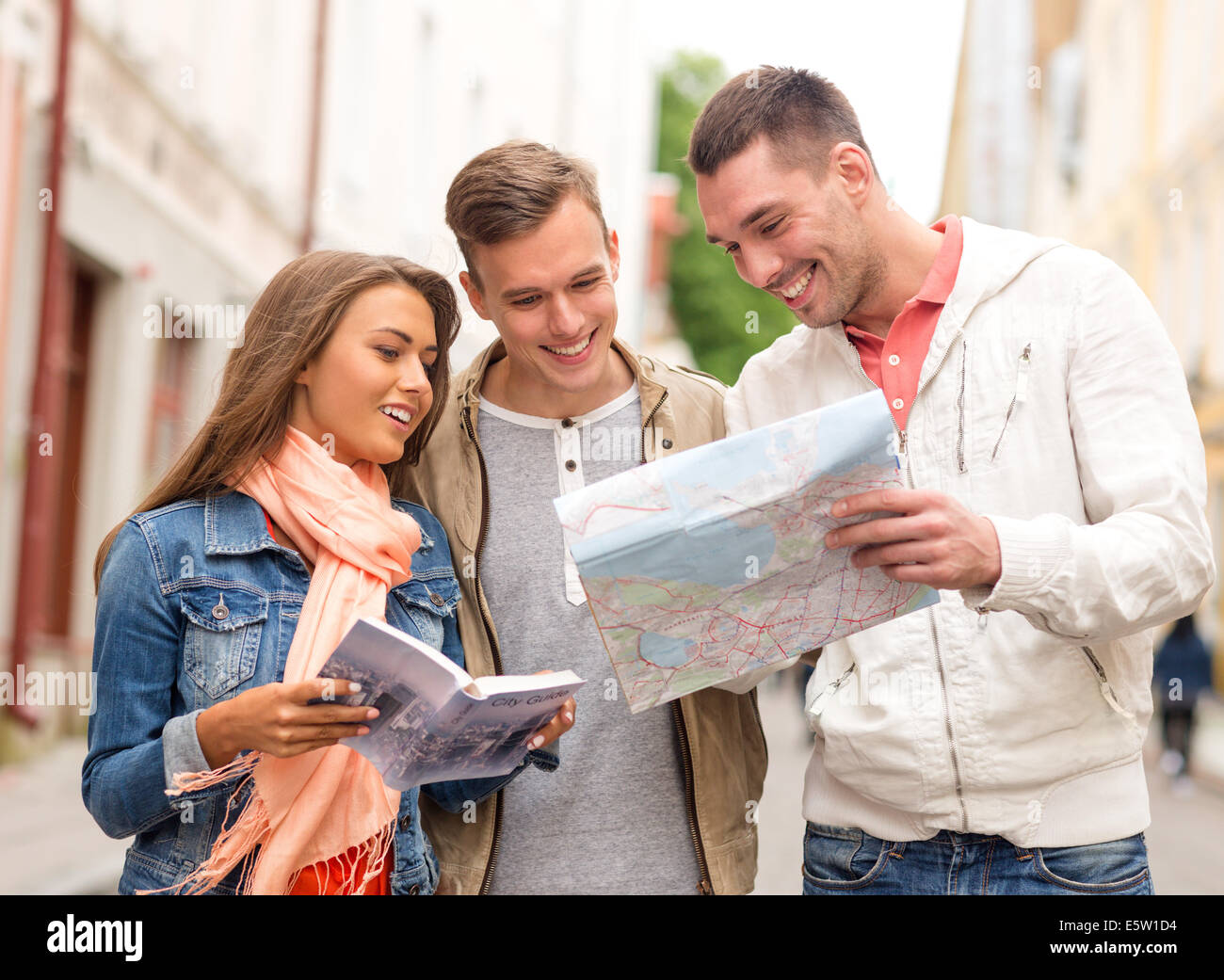 group of smiling friends with city guide and map Stock Photo - Alamy
