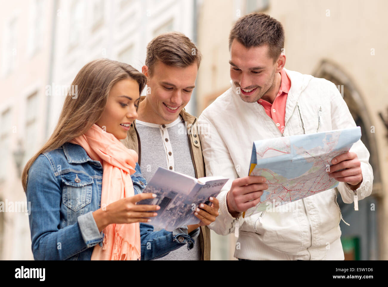 group of smiling friends with city guide and map Stock Photo - Alamy
