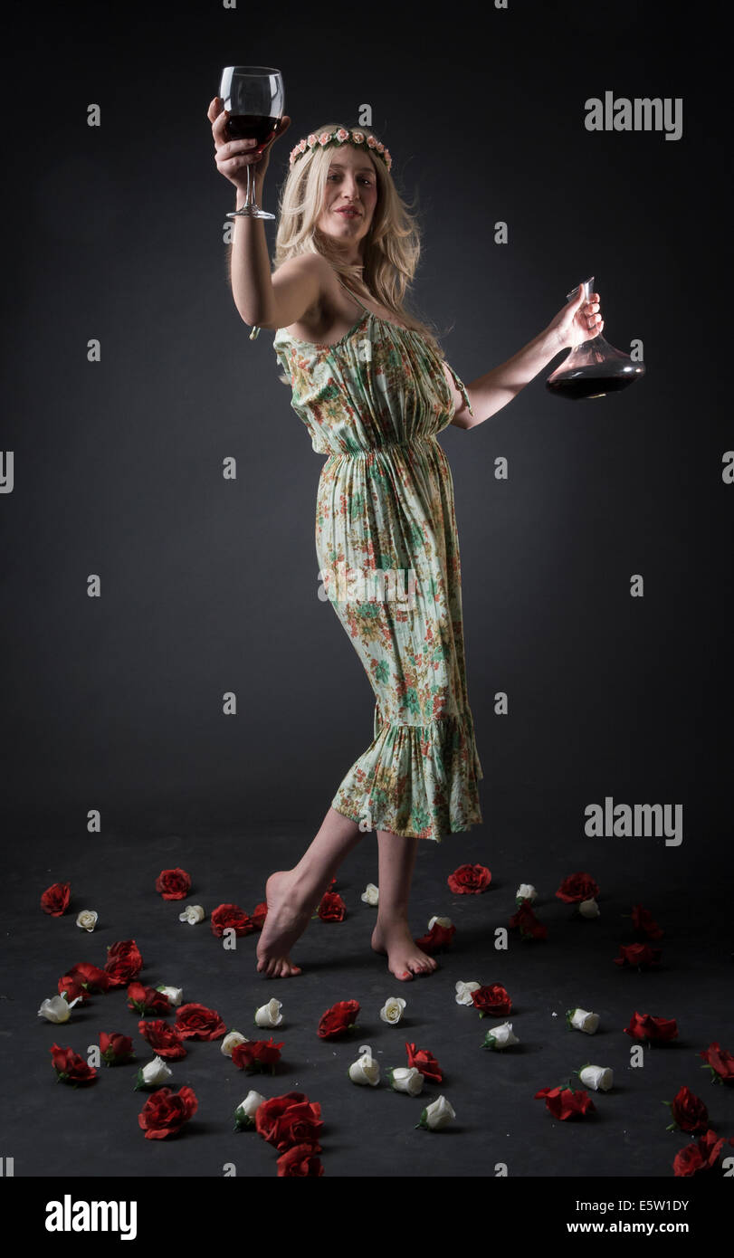 Cheerful girl toasting with a cup and bottle of wine Stock Photo - Alamy