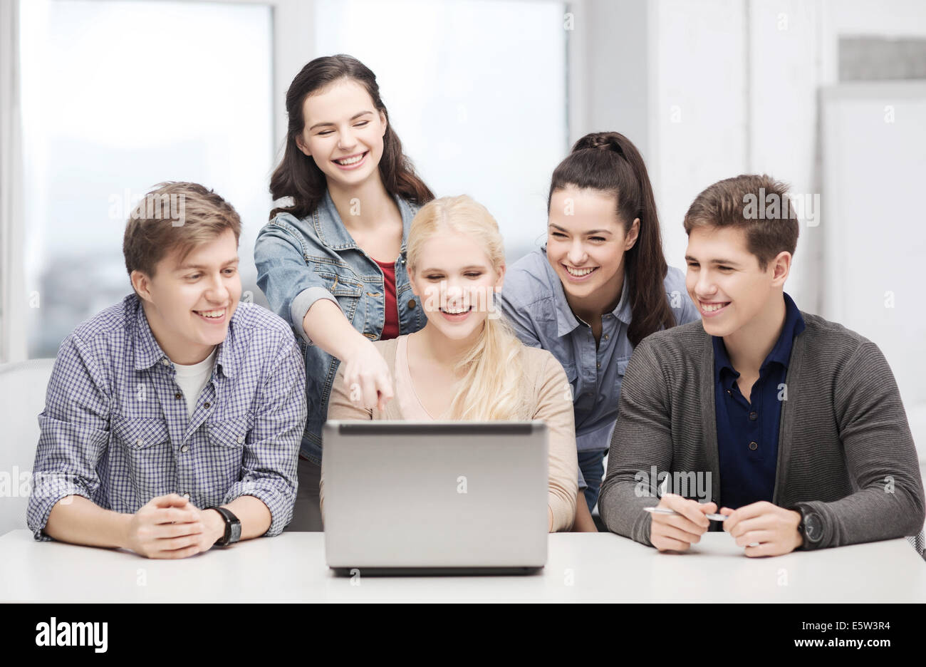 smiling students looking at laptop at school Stock Photo - Alamy