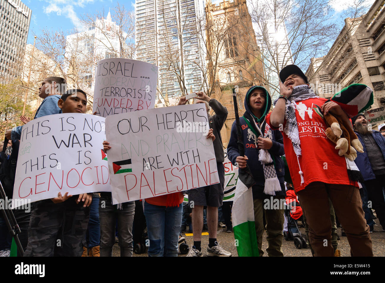 Children cheer and hold banners supporting Palestine in a rally against ...