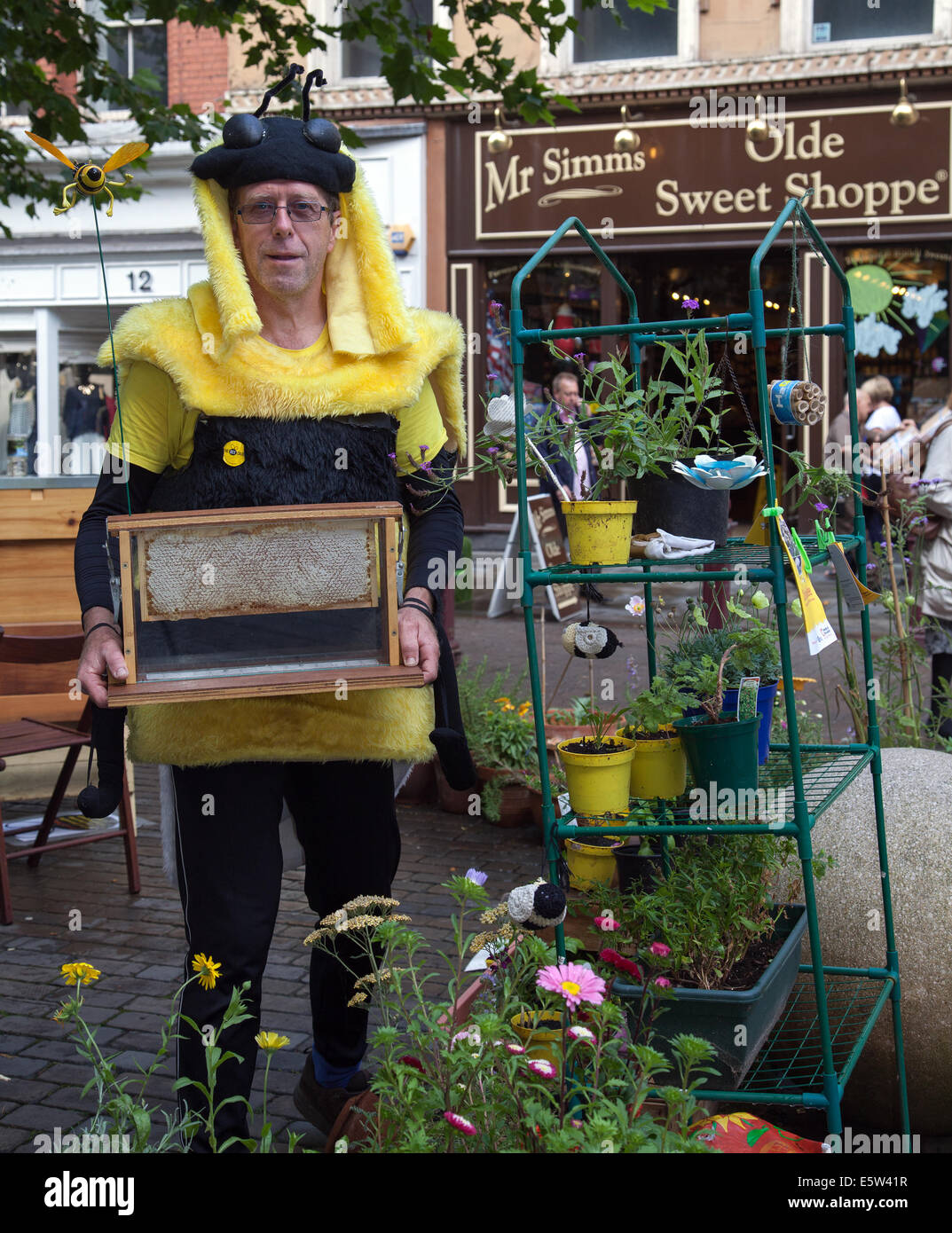 Man in bee costume holidng beehive honeycomb in Manchester, UK Friends ...