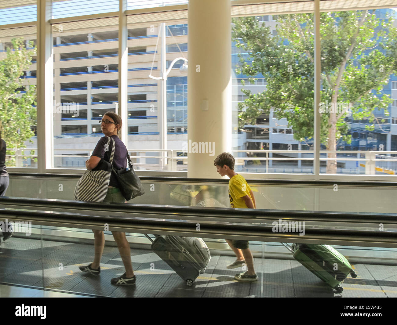 Mother and Child Pulling Luggage on Moving Sidewalk, Minneapolis/ St ...