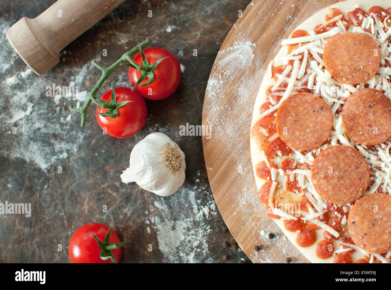 Pepperoni pizza preparation with rolling pin and fresh Stock Photo - Alamy