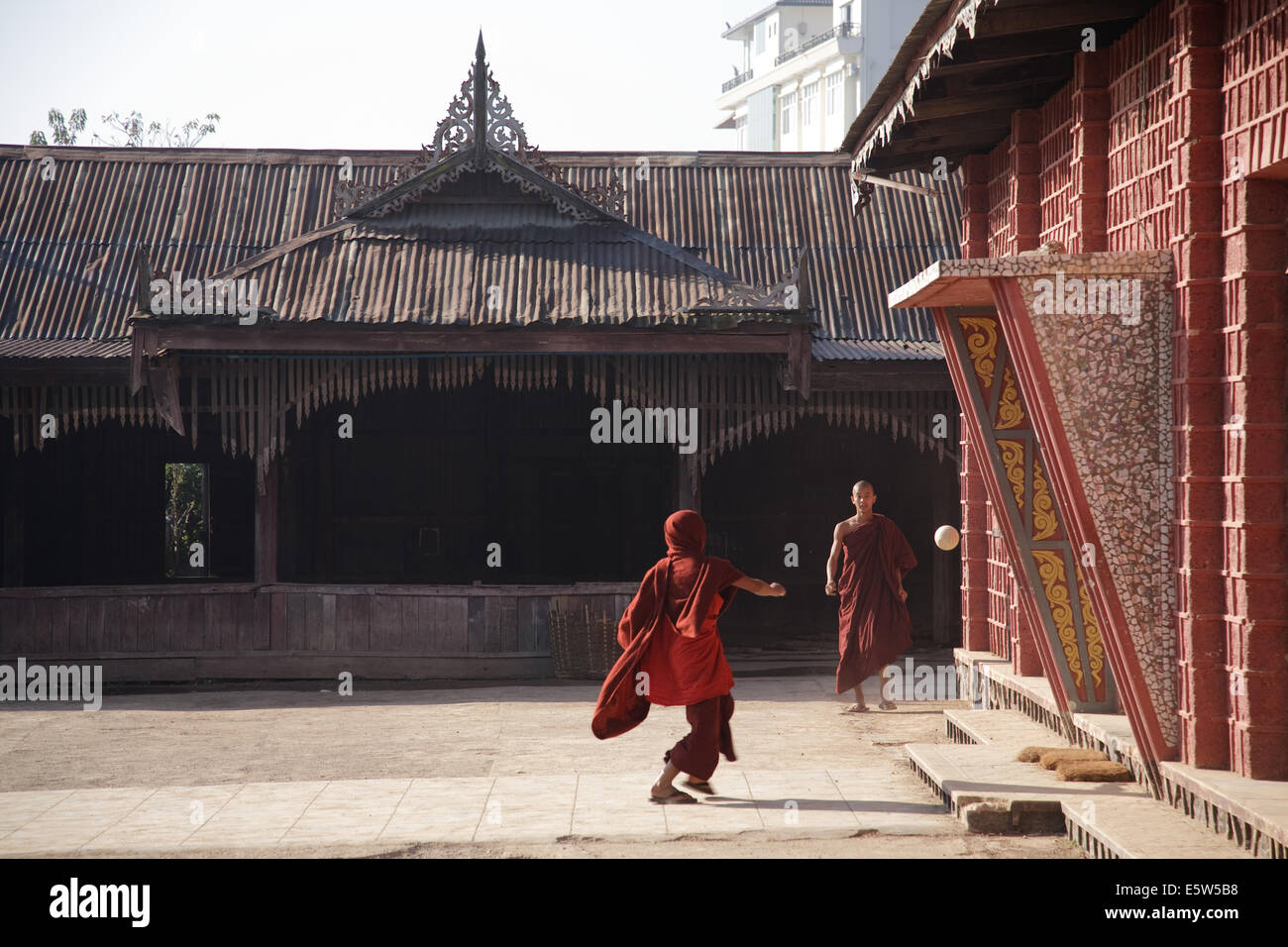 Young monks kicking a ball in a yard outside a monastery in Nyuangshwe ...