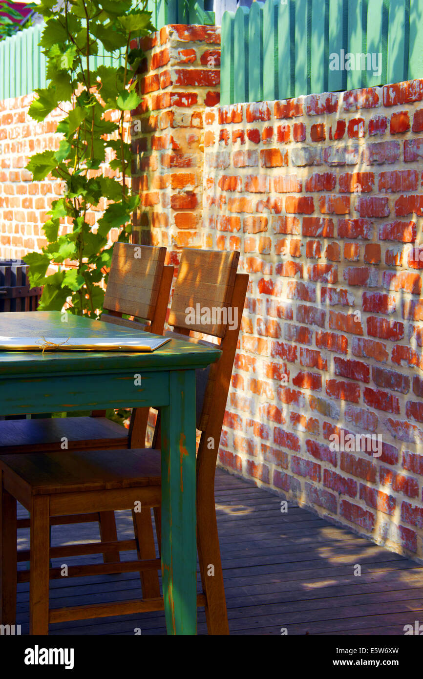 table in garden with stone wall Stock Photo - Alamy