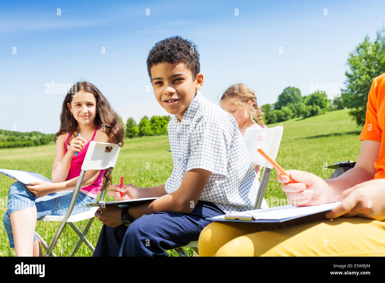 Kids drawing in sketch-boards and sit on chairs Stock Photo - Alamy
