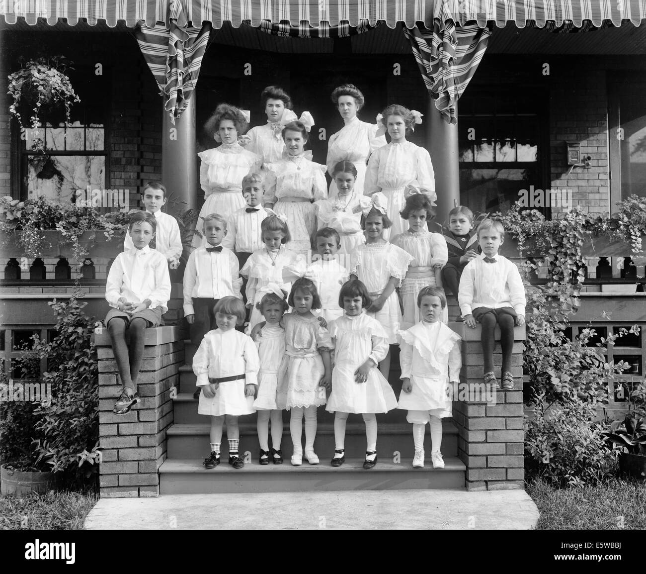 Children and women on steps of house, possibly school children and ...