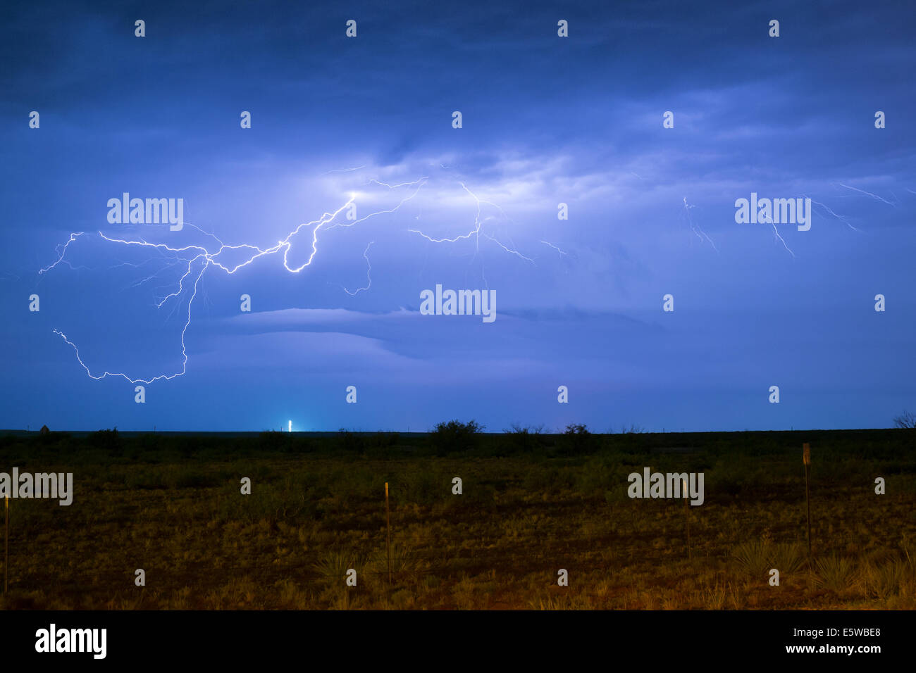 Lightning strikes the ground and flashes across the night sky Stock ...