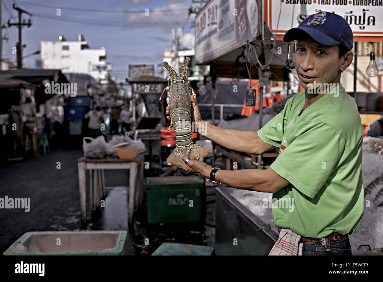 Thailand Fish vendor displaying a large lobster for sale at the street ...